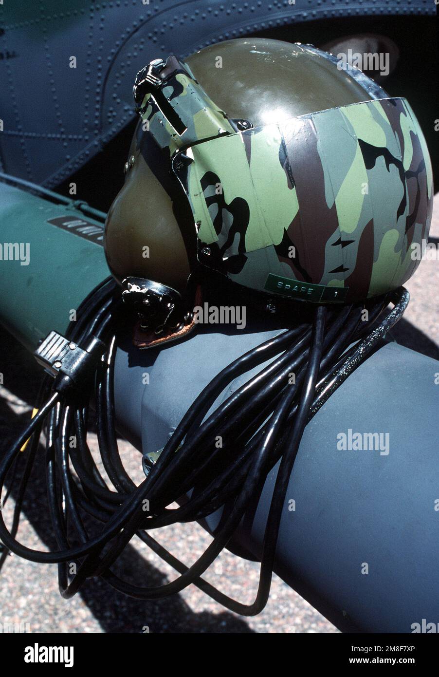 A close-up view of a helmet and radio headset on the refueling probe of ...