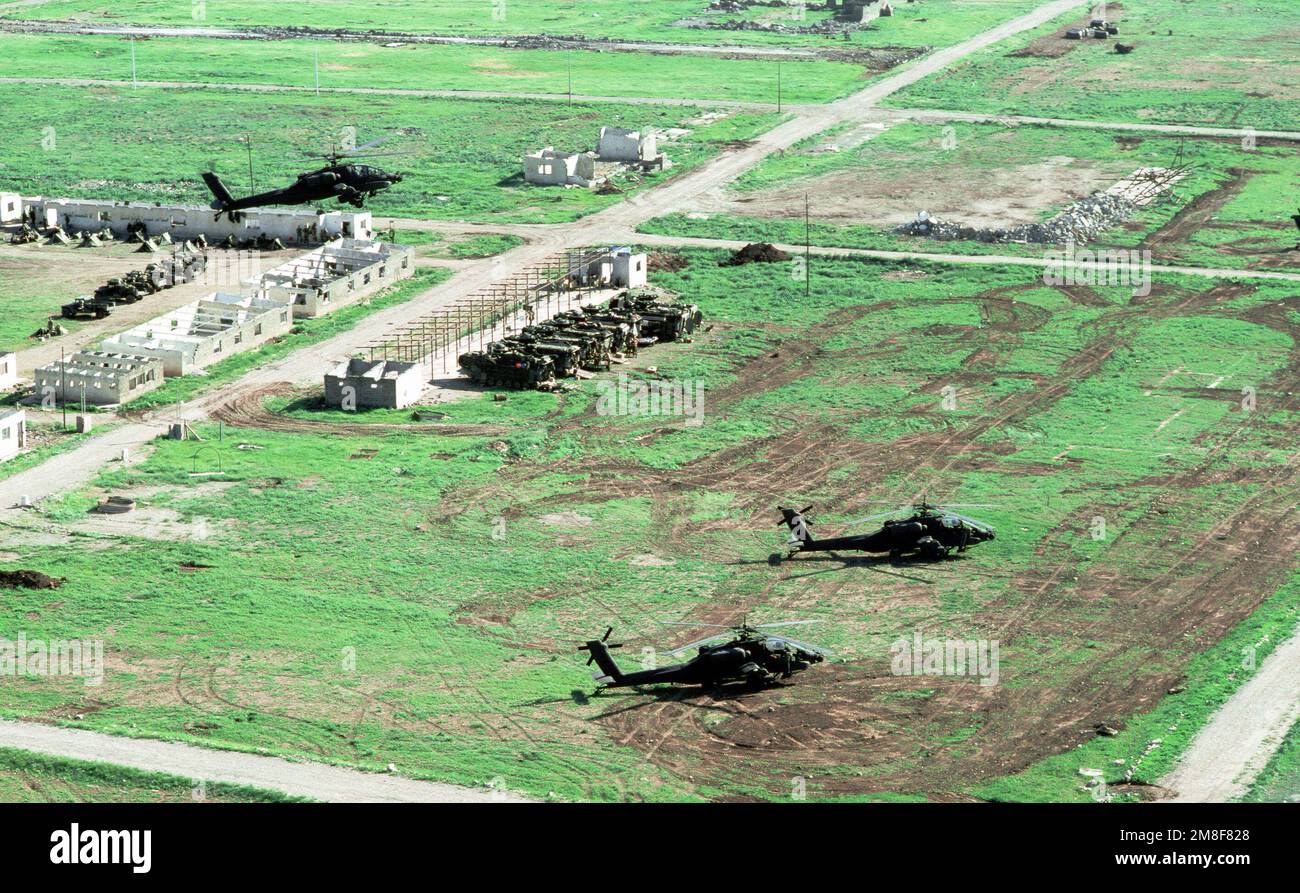 An AH-64 Apache helicopter comes in for a landing as two other Apaches ...