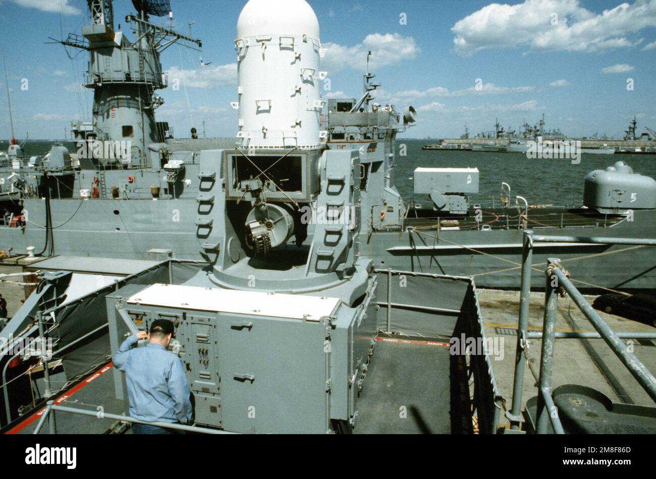 A gunner's mate opens an access panel to perform maintenance on a Mark ...