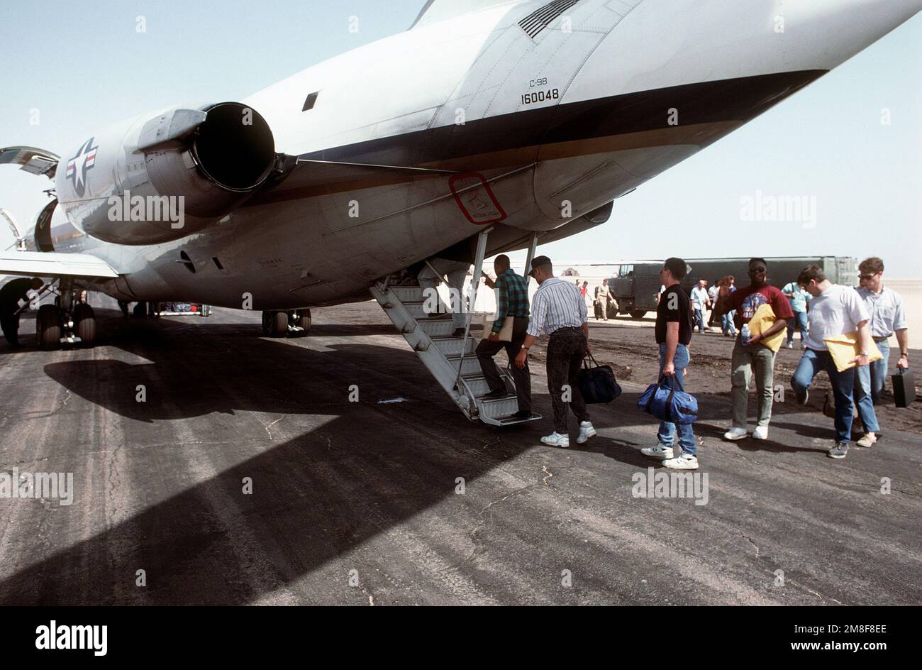 U.S. military personnel board a C-9B Skytrain II aircraft as they begin ...