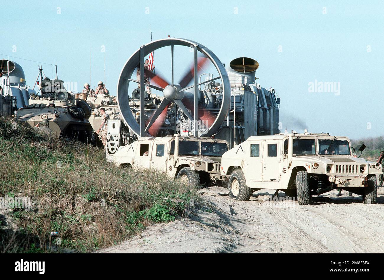An M998 High-Mobility Multipurpose Wheeled Vehicle (HMMWV), right, and ...