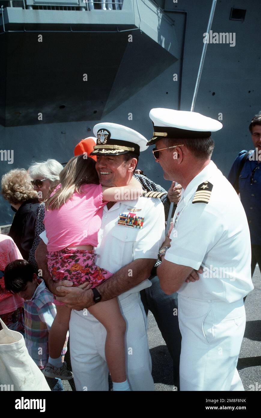 An officer is reunited with his daughter as a fellow officer stands by ...
