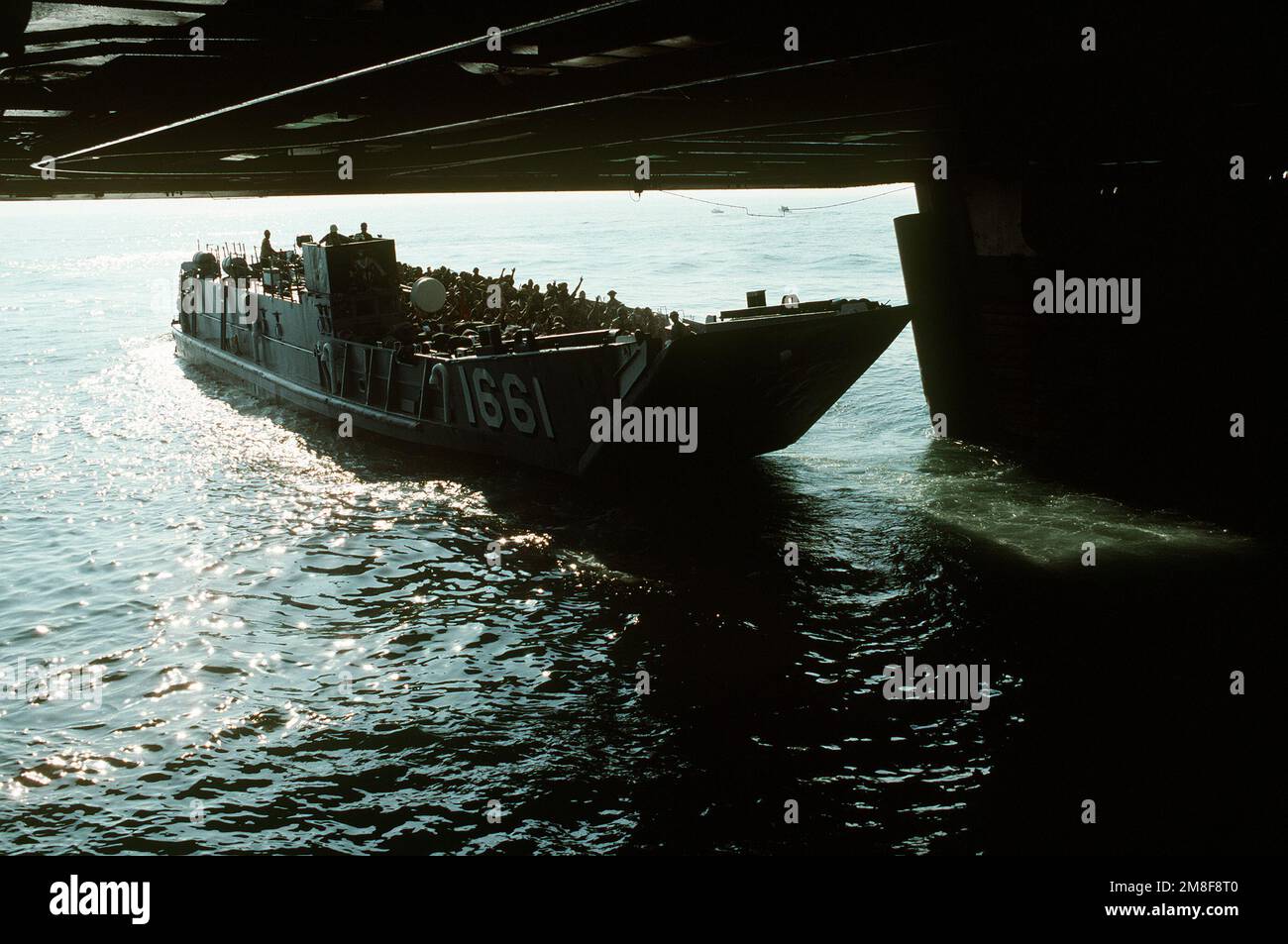 The utility landing craft LCU-1661 backs out of the well deck of the ...