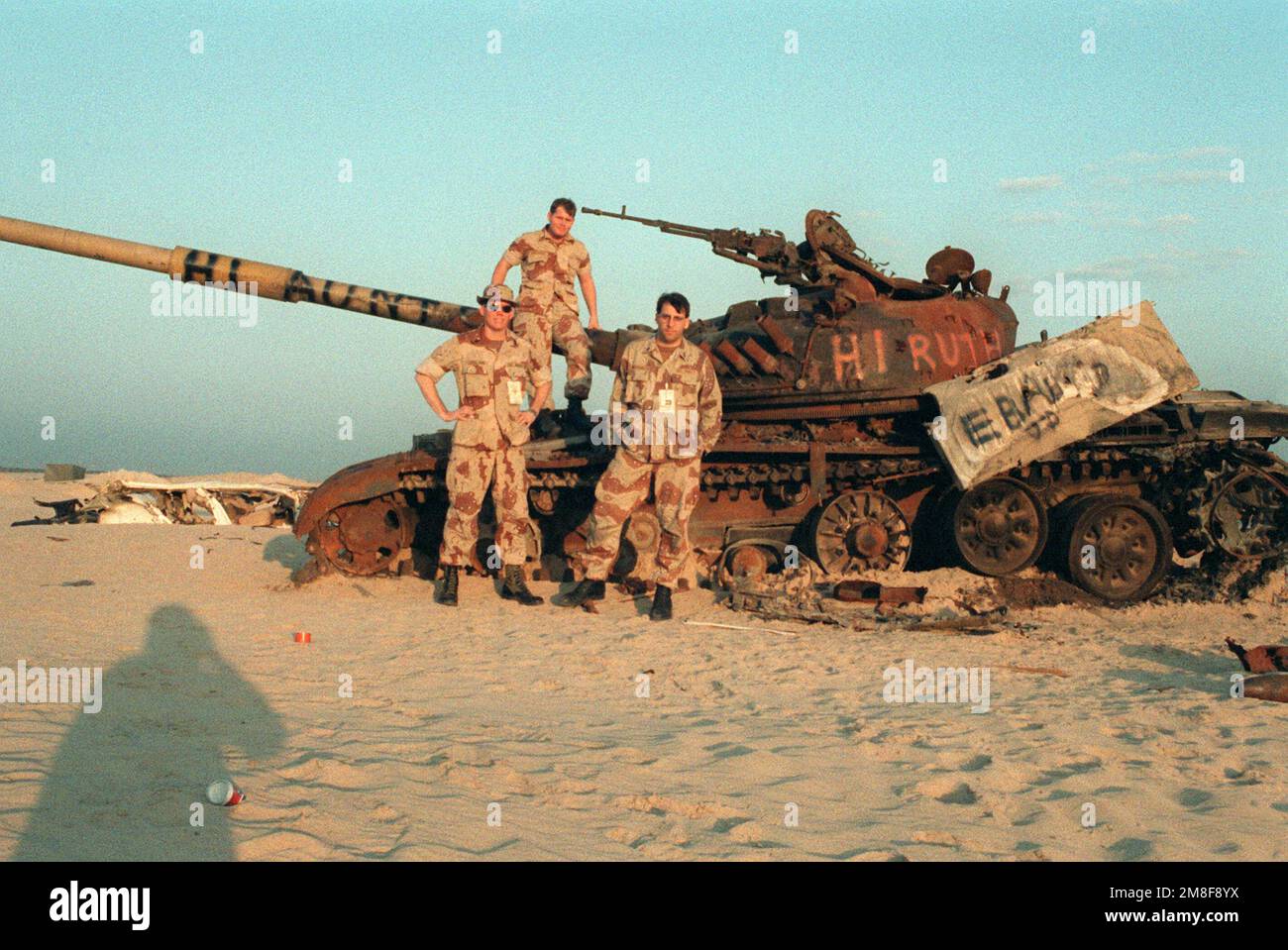Members of a media team pose in front of an Iraqi T-72 main battle tank ...