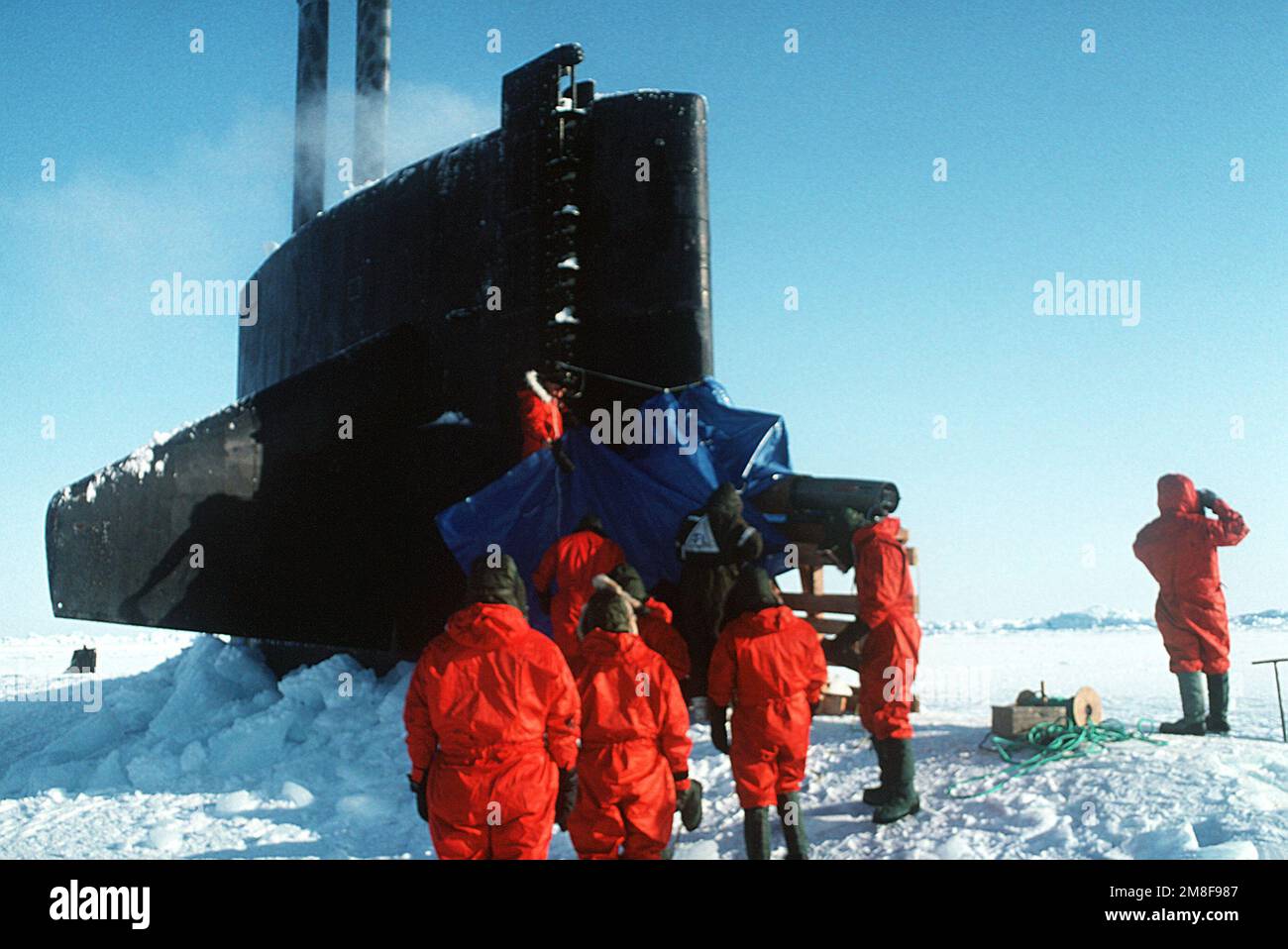 Crew members gather near the sail of the nuclear-powered attack submarine USS PARGO (SSN-650 ...