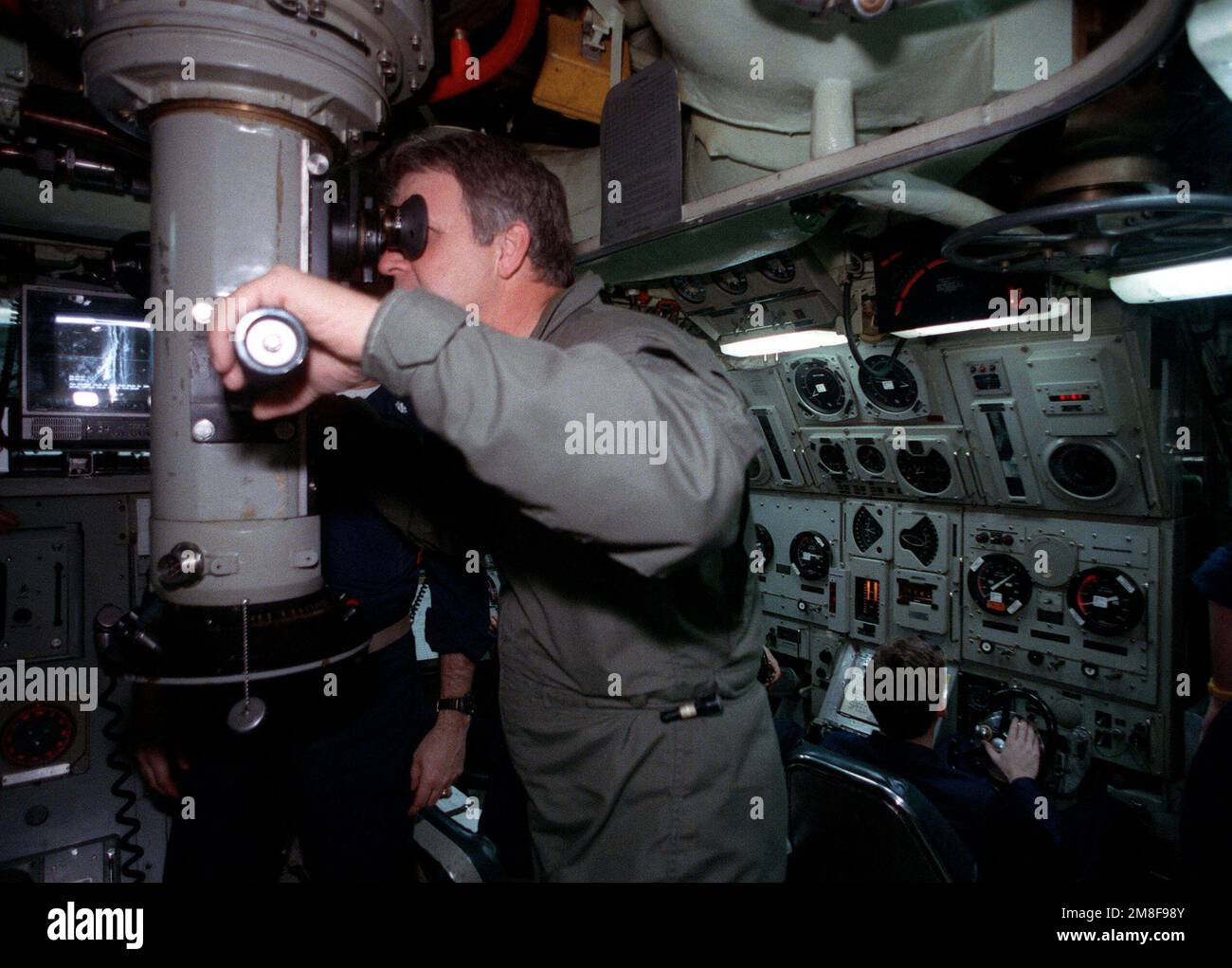 Undersecretary of the Navy Daniel Howard looks though the periscope of ...