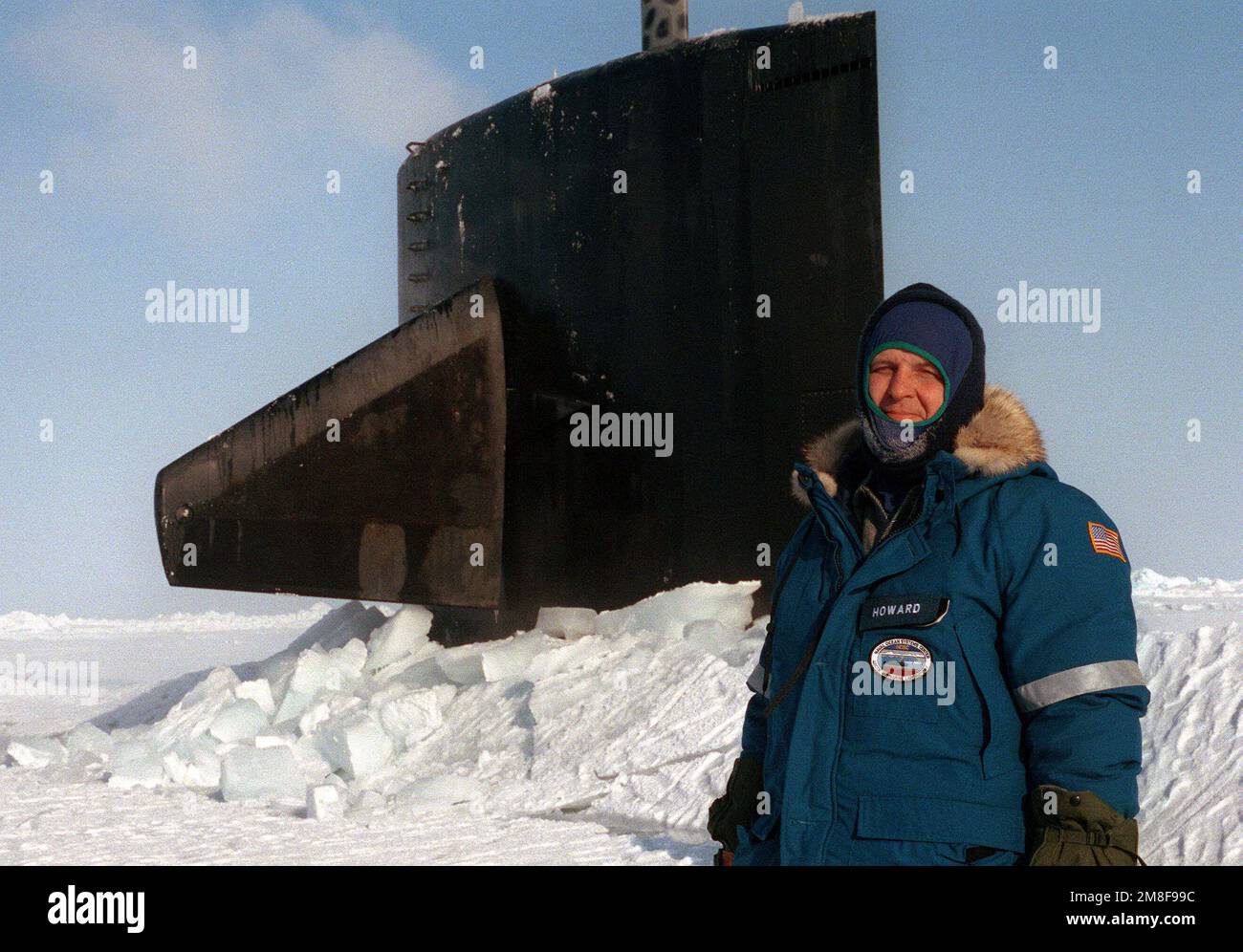 Undersecretary of the Navy Daniel Howard stands on the ice in front of ...