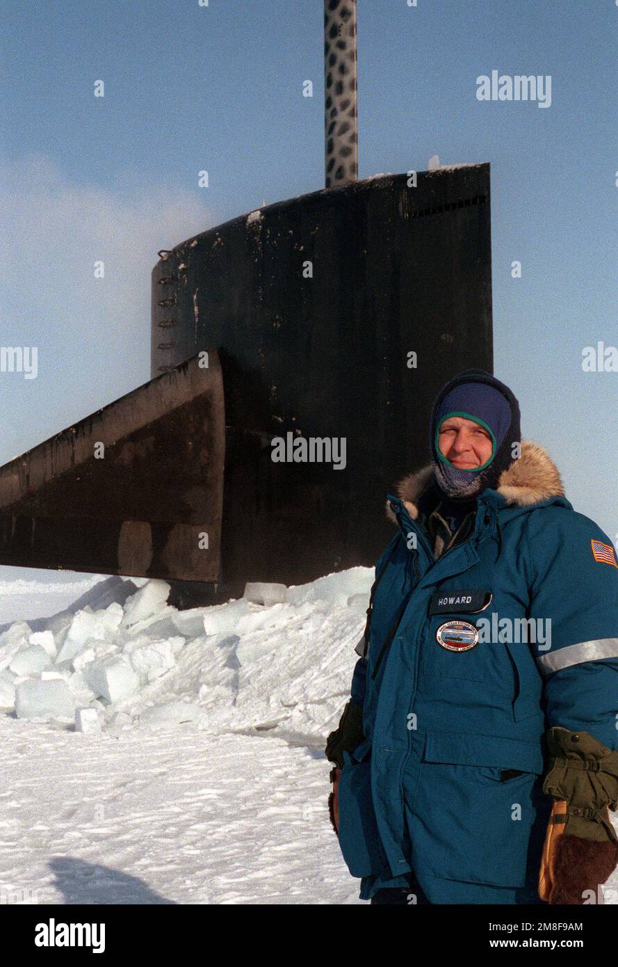 Undersecretary of the Navy Daniel Howard stands on the ice in front of ...