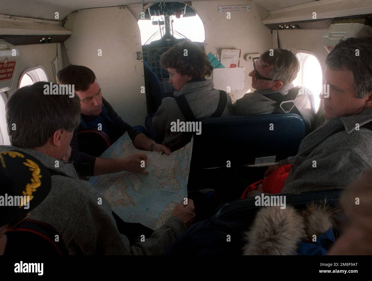 Members of an official party ride aboard a chartered aircraft while en ...
