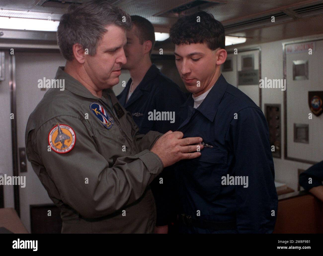 Undersecretary of the Navy Daniel Howard pins a submarine insignia to ...