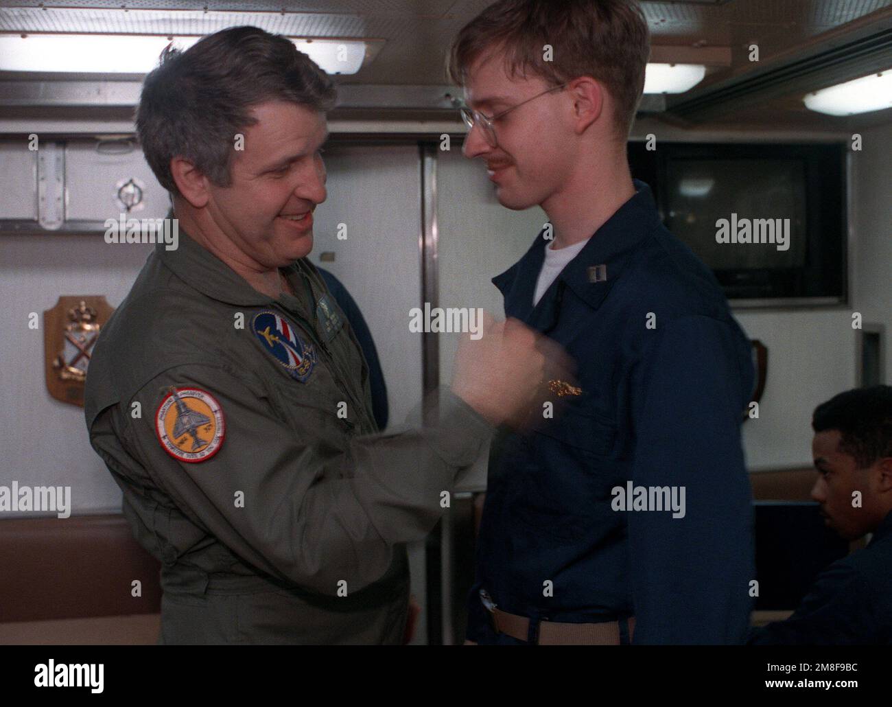 Undersecretary of the Navy Daniel Howard pins a submarine insignia on ...