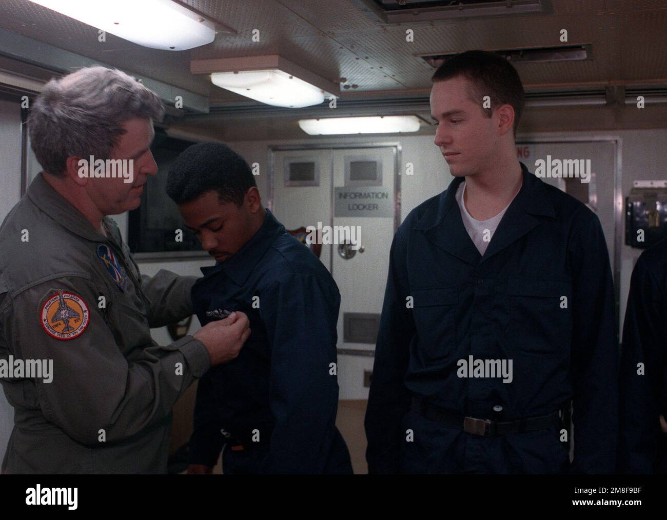 Undersecretary of the Navy Daniel Howard pins a submarine insignia to ...