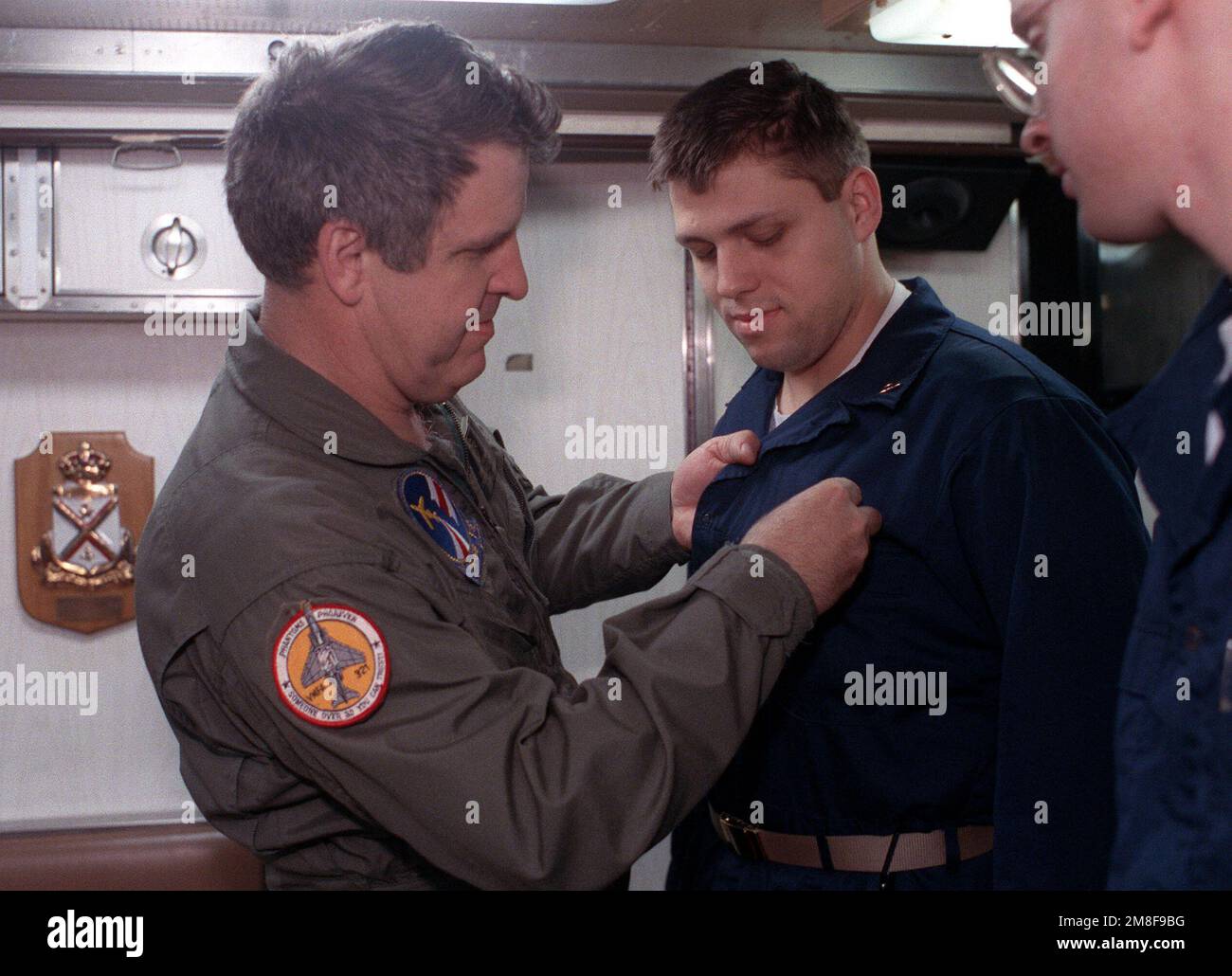 Undersecretary of the Navy Daniel Howard pins a submarine insignia to ...