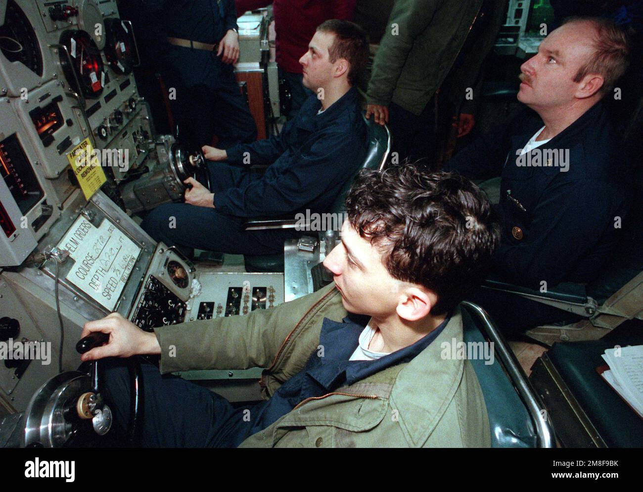 A chief petty officer supervises the helmsmen aboard the nuclear ...