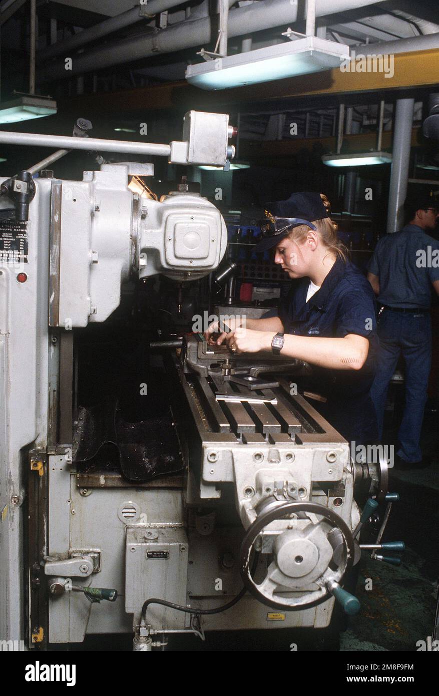 Machinery Repairman/Fireman 3rd Class Kim Cooney hones a piece of metal ...