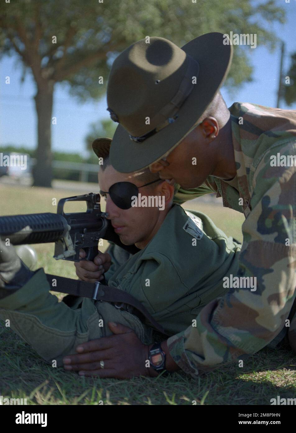 A 2nd Battalion recruit assumes the prone firing position with the help ...