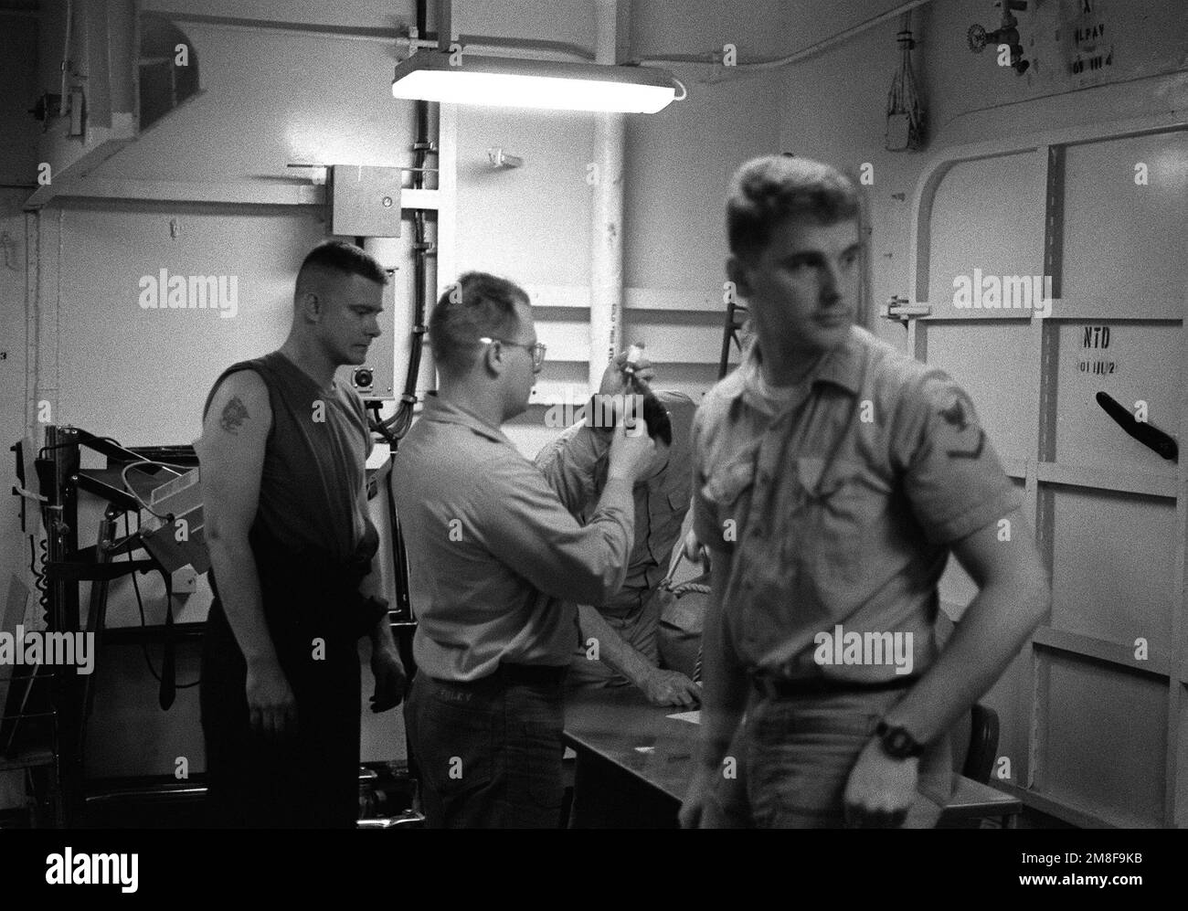 A hospital corpsman administers inoculations in the sick bay aboard the ...