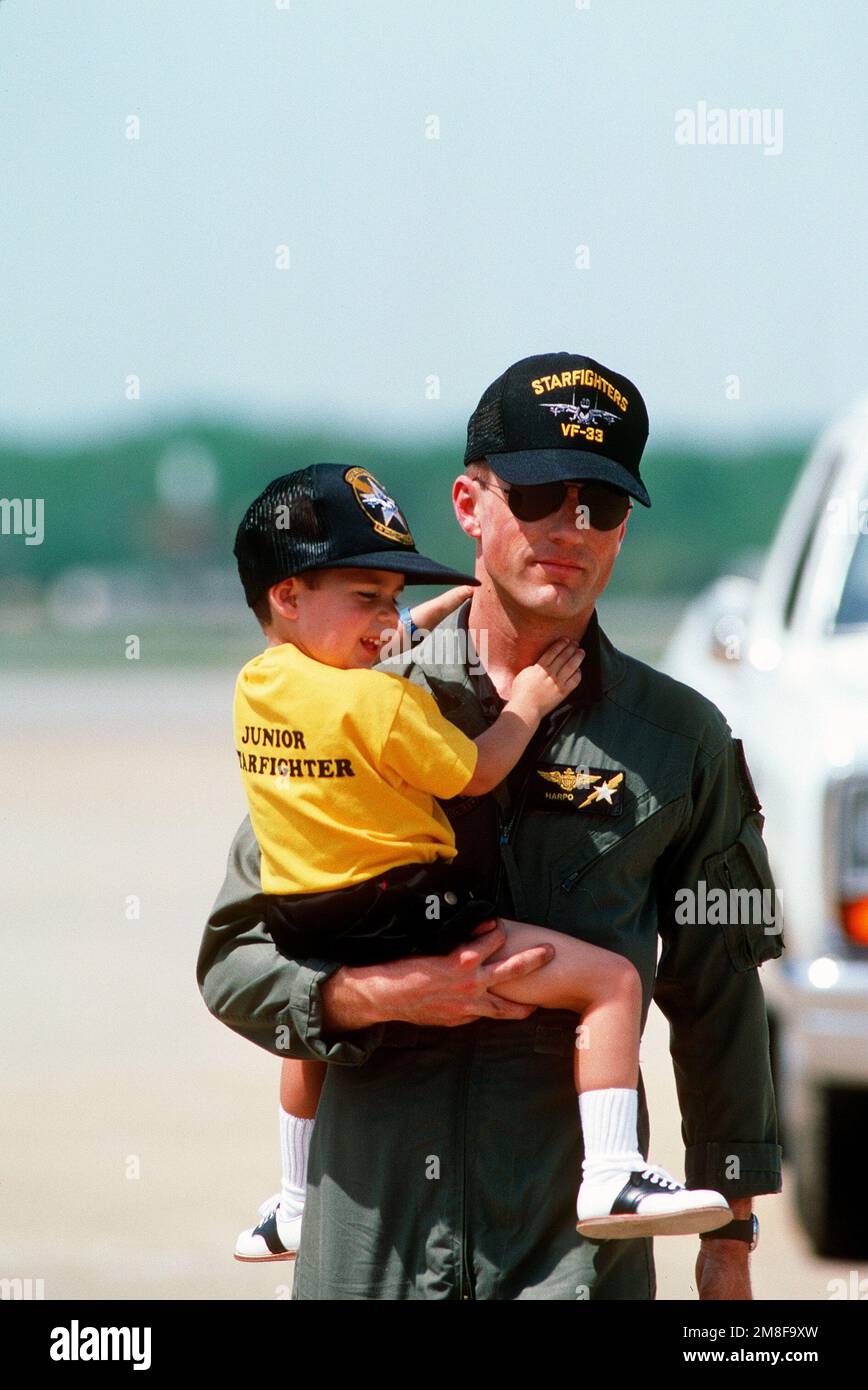 A pilot from Fighter Squadron 33 (VF-33) holds his son shortly after ...
