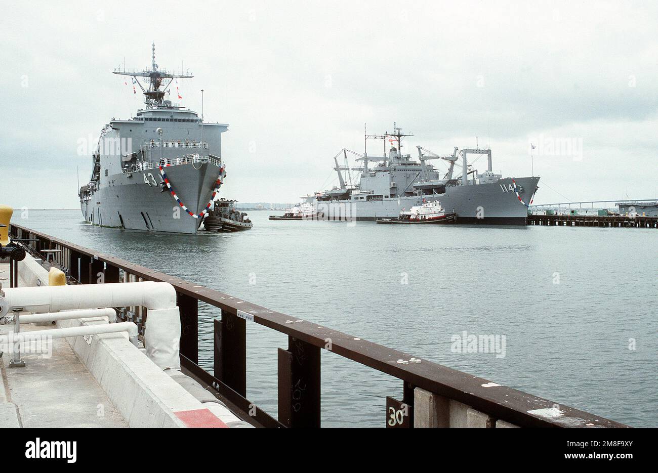 The large harbor tug CANONCHET (YTB-823) maneuvers the dock landing ...