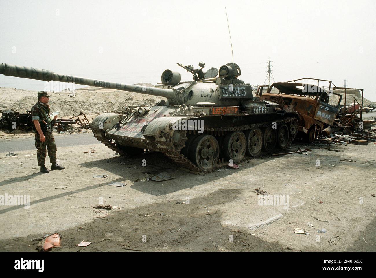 A Marine examines an Iraqi T-55 main battle tank, abandoned on Highway ...