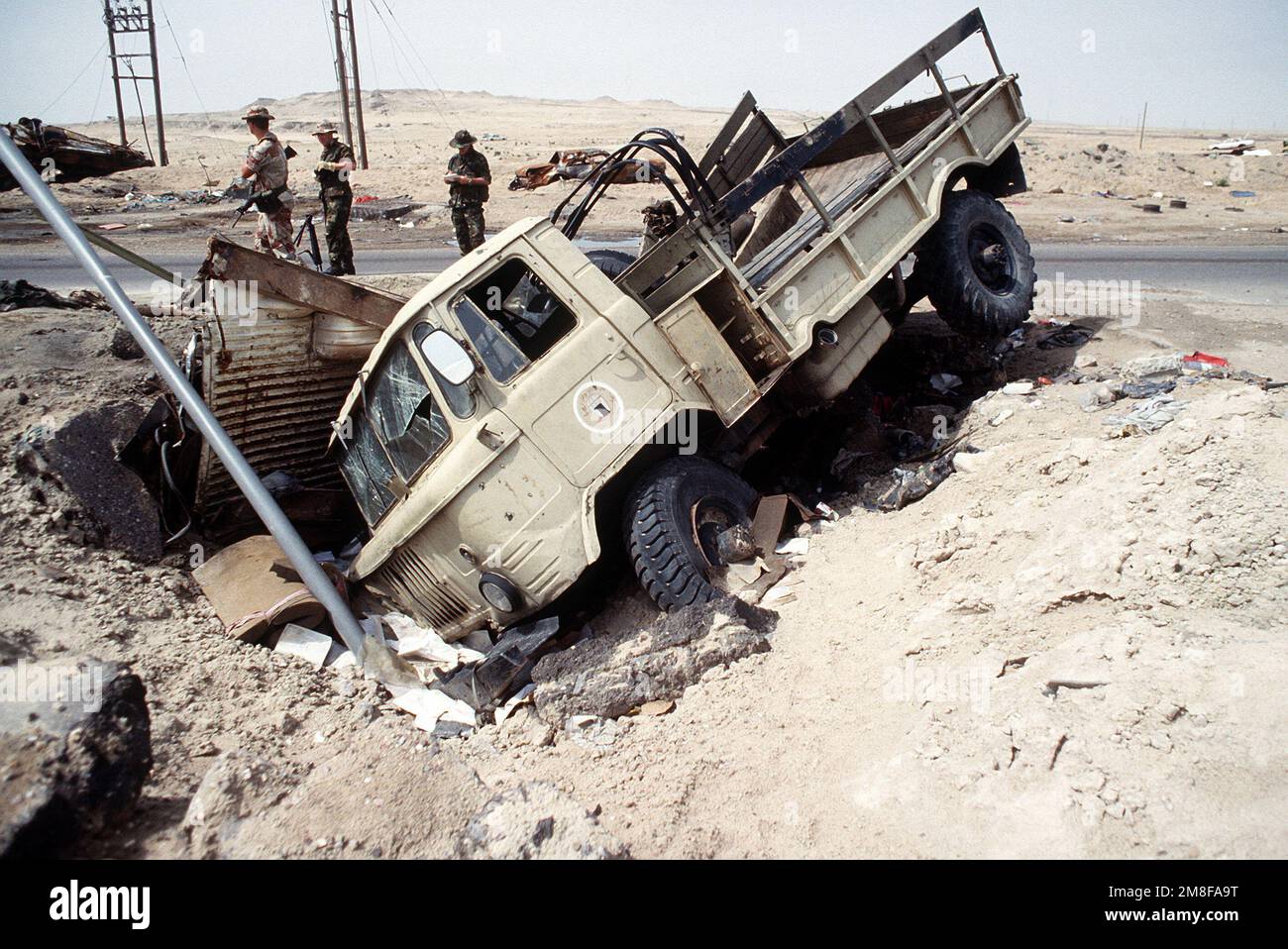 U.S. soldiers inspect Iraqi vehicles destroyed on Highway 8 during ...