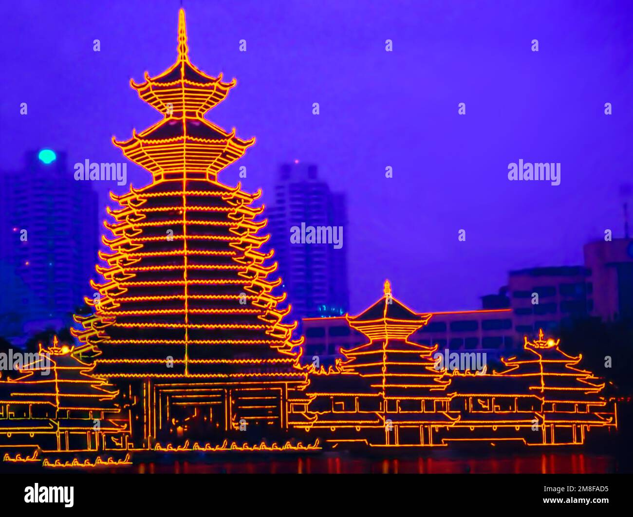 Chinese traditional Buddhist pagoda illuminated by neon lights at night ...
