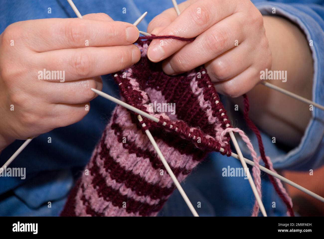 Two hands knitting a wool sock Stock Photo - Alamy
