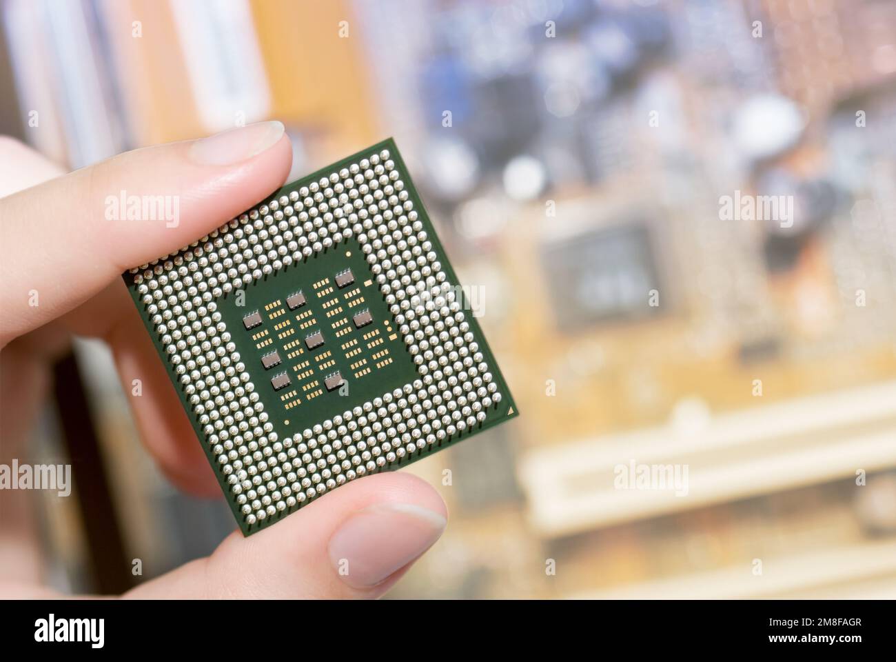 Computer processor in a hand against motherboard Stock Photo - Alamy