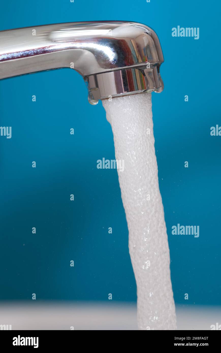 Water stream running out of chrome mixing faucet Stock Photo - Alamy
