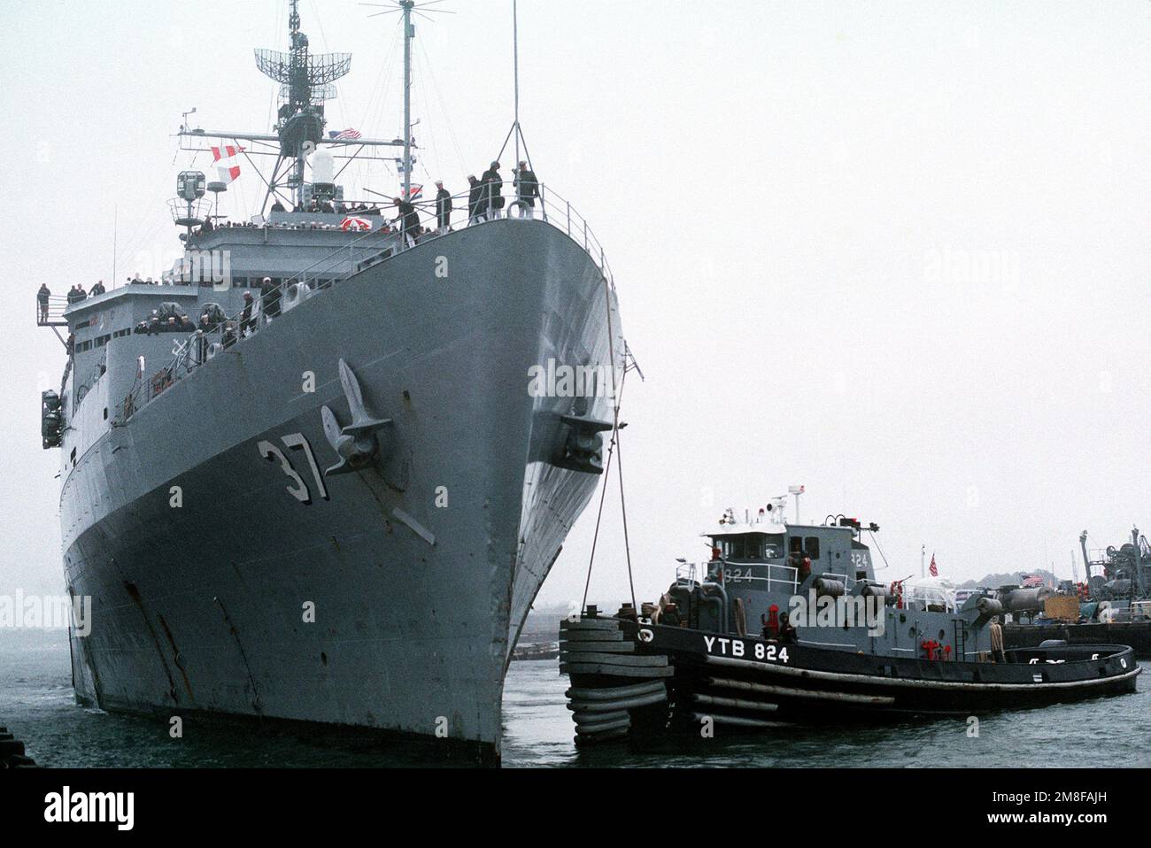The large harbor tug SANTAQUIN (YTB-824) moves the dock landing ship ...