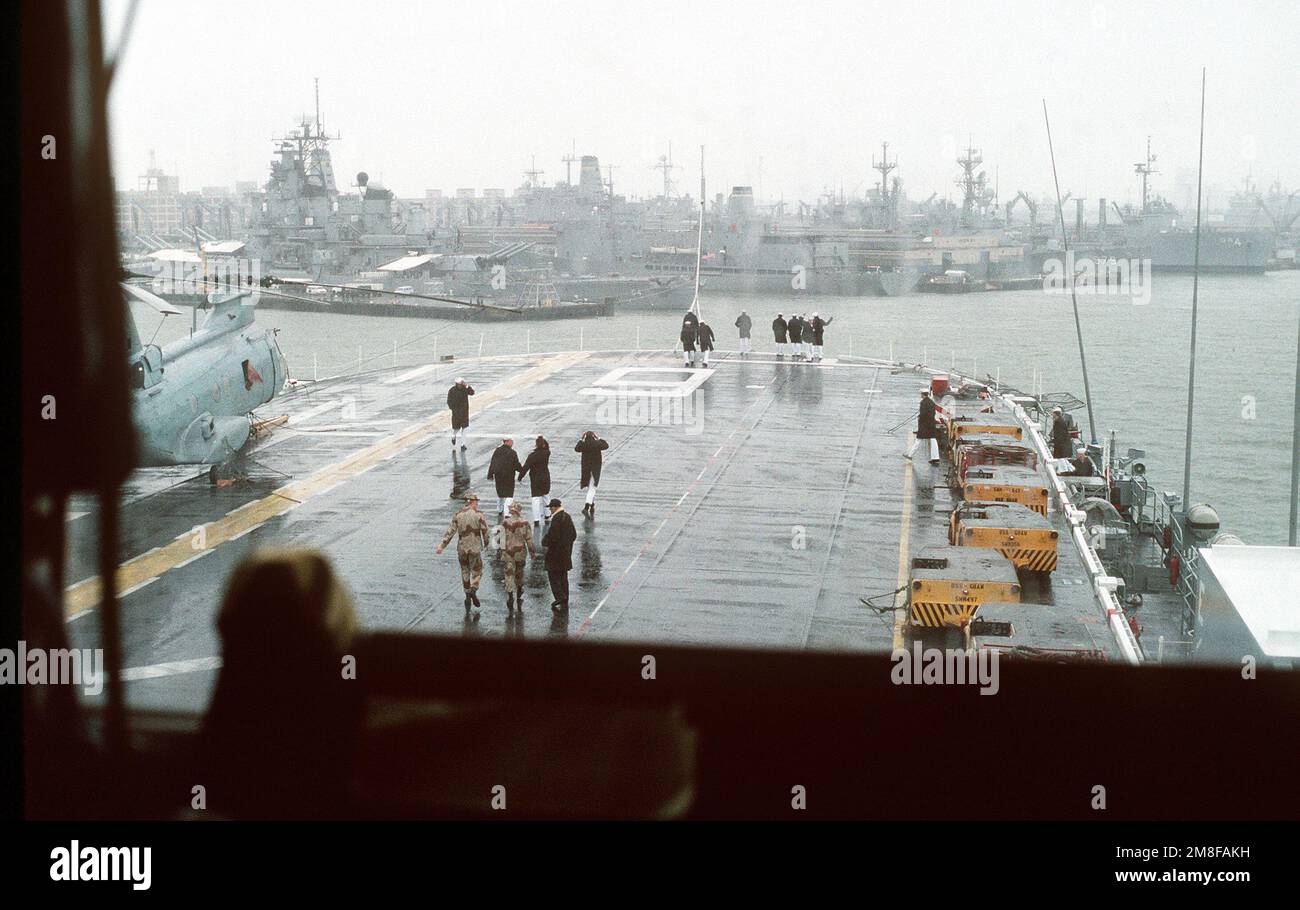Crew members aboard the amphibious assault ship USS GUAM (LPH-9) brave ...