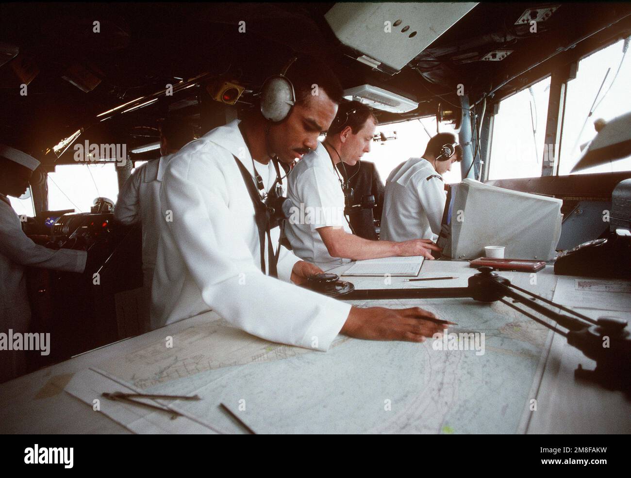 A quartermaster working on the bridge of the amphibious assault ship ...
