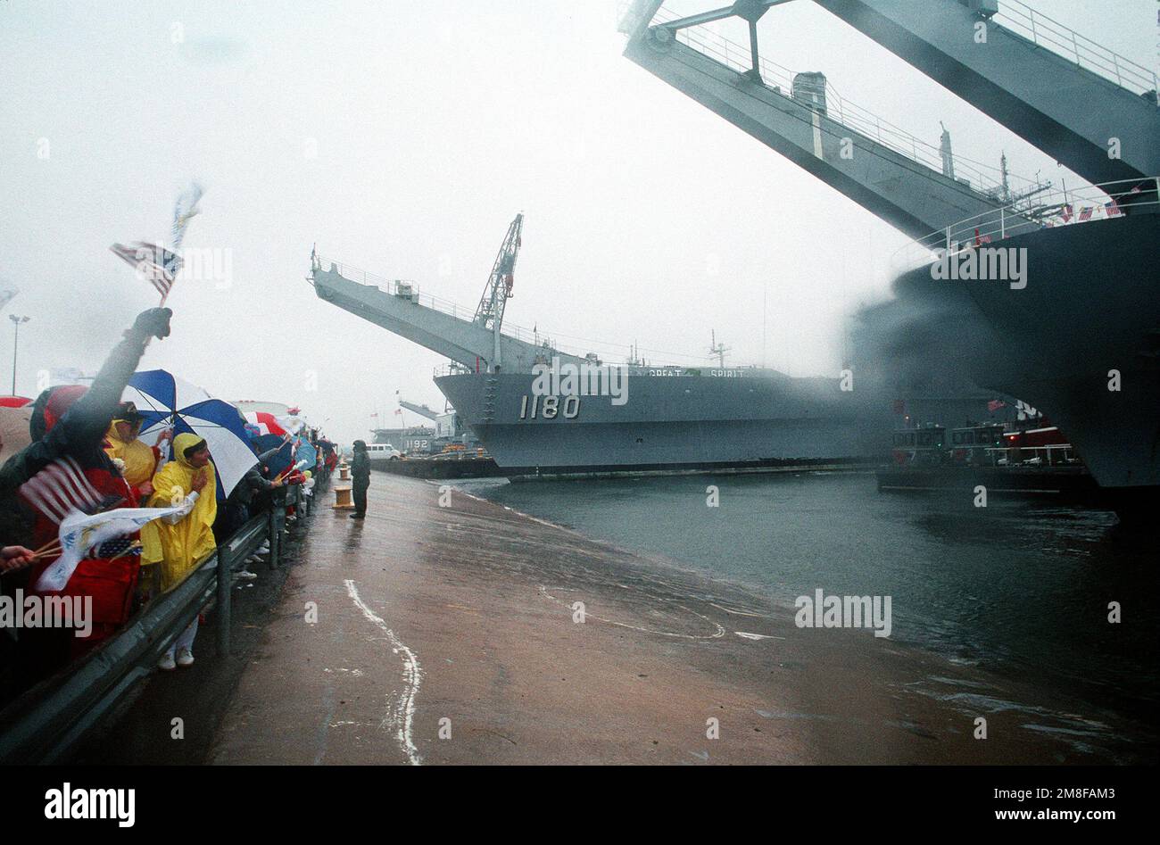 The tank landing ship USS LAMOURE COUNTY (LST-1194), right, arrives at ...