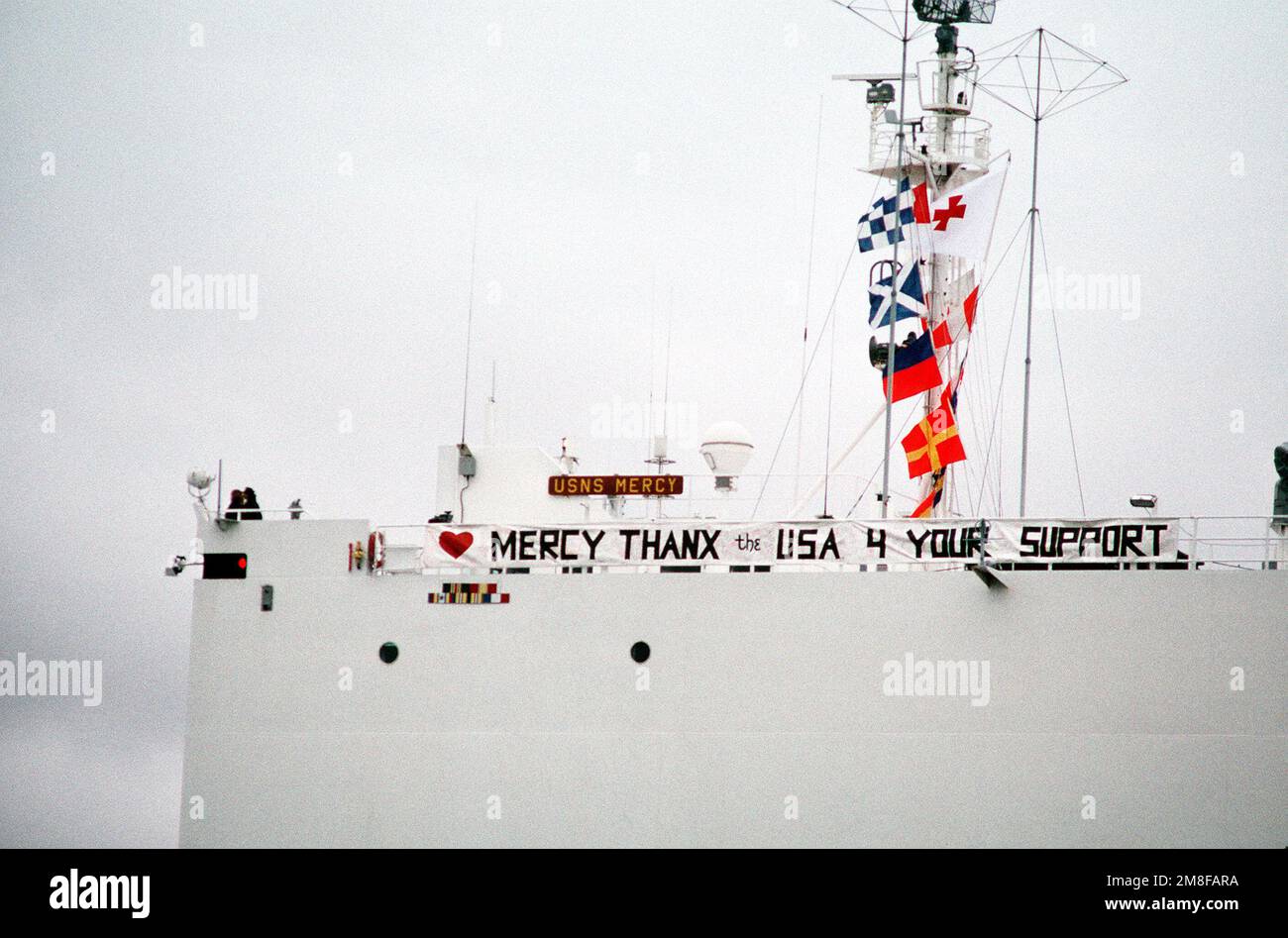 A banner on the railing of the hospital ship USNS MERCY (T-AH-19 ...