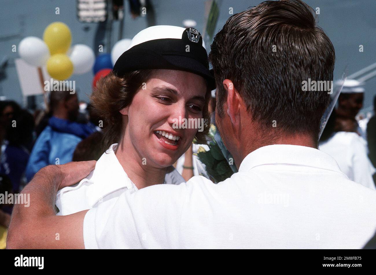 A sailor from the destroyer tender USS ACADIA (AD-42) is greeted by one ...