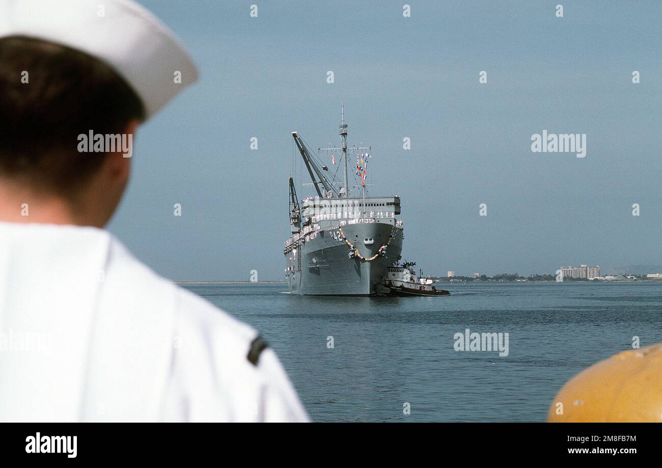 A line handler watches from the pier as a commercial tug guides the ...