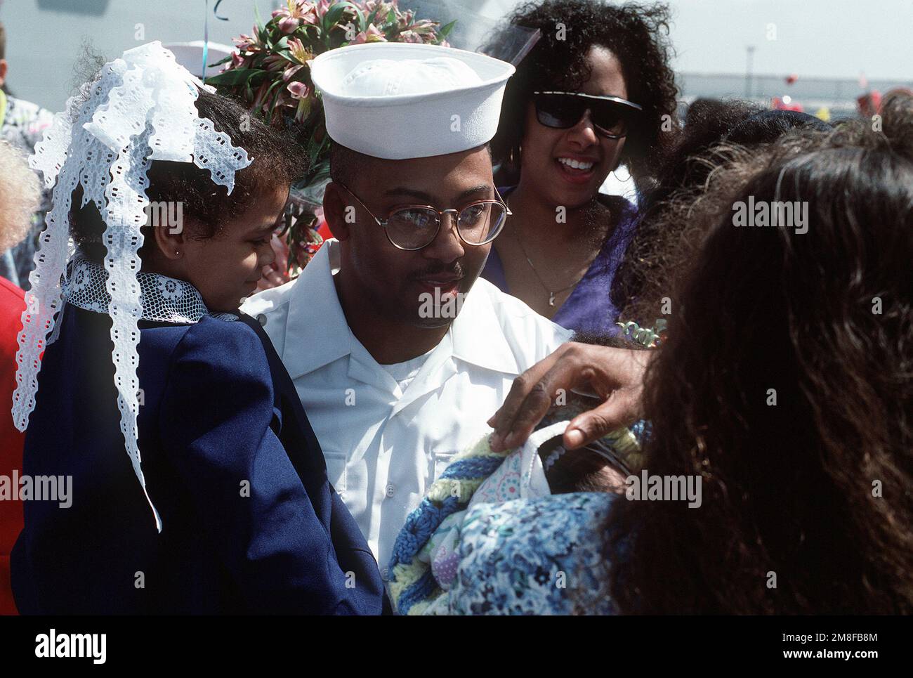A sailor from the destroyer tender USS ACADIA (AD-42) is reunited with ...