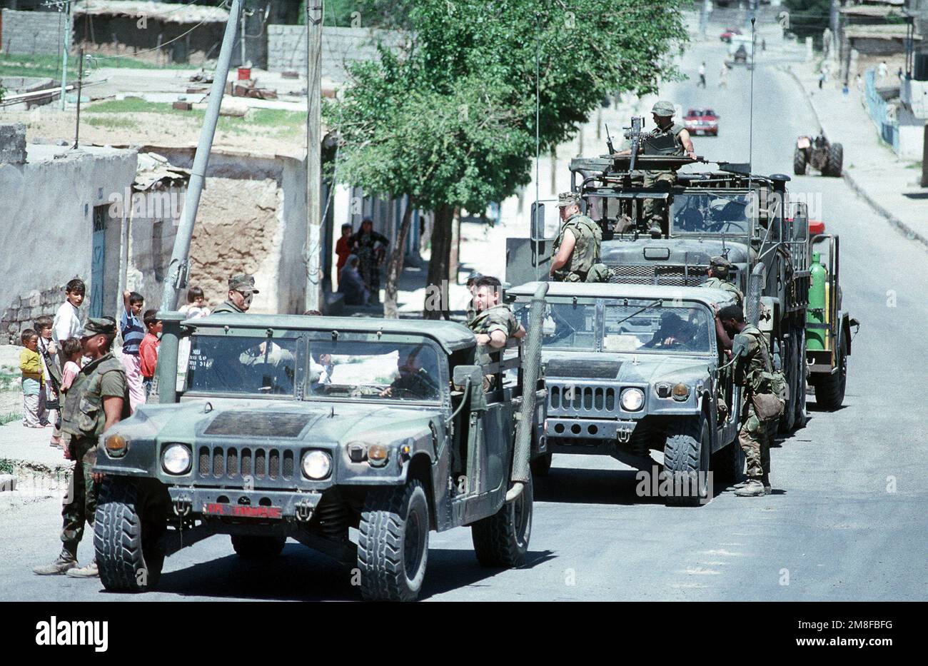 A convoy of two M998 High-Mobility Multipurpose Wheeled Vehicles (HMMWV ...