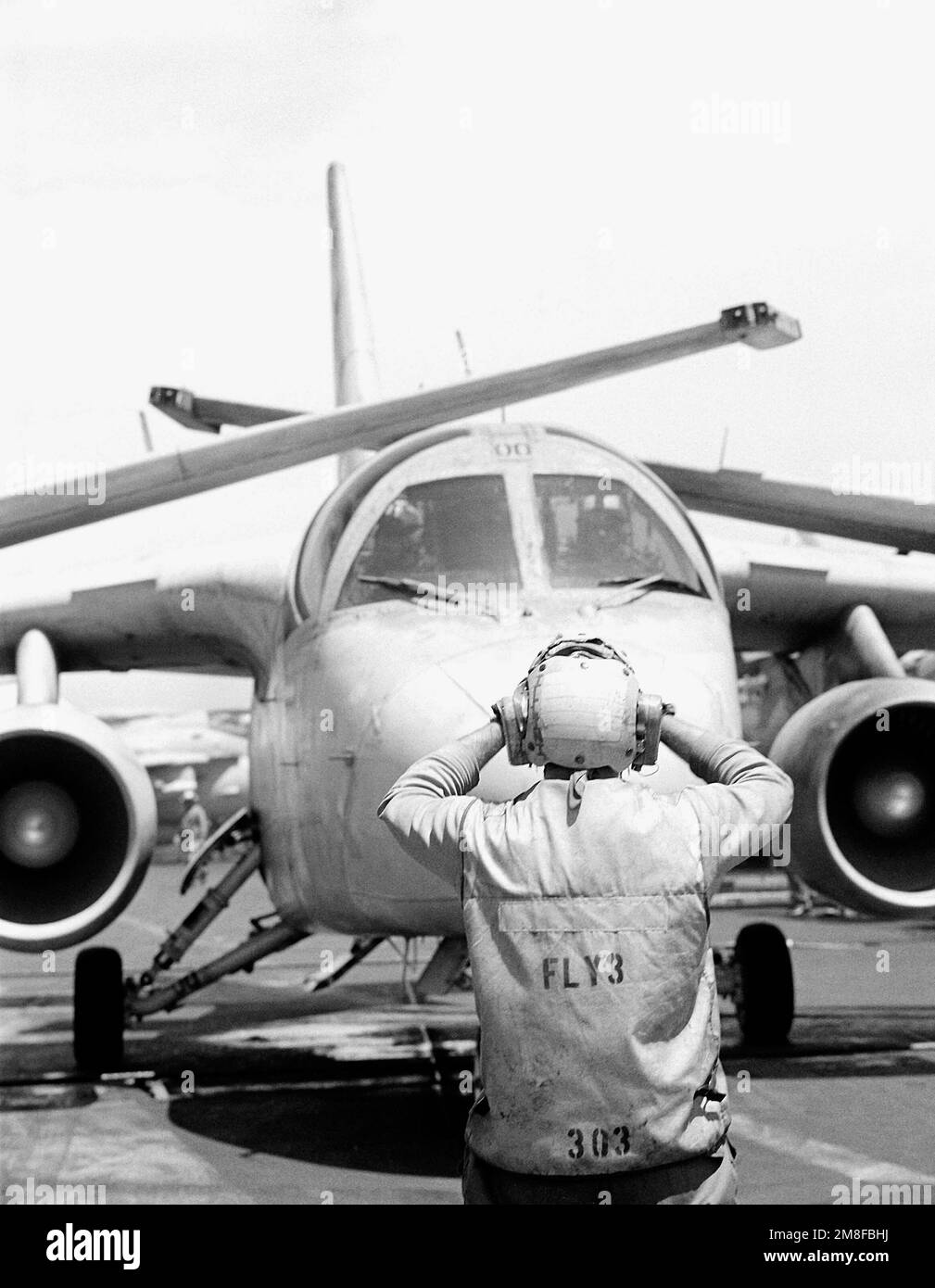 A plane director signals to the pilot of an Air Anti-submarine Squadron ...