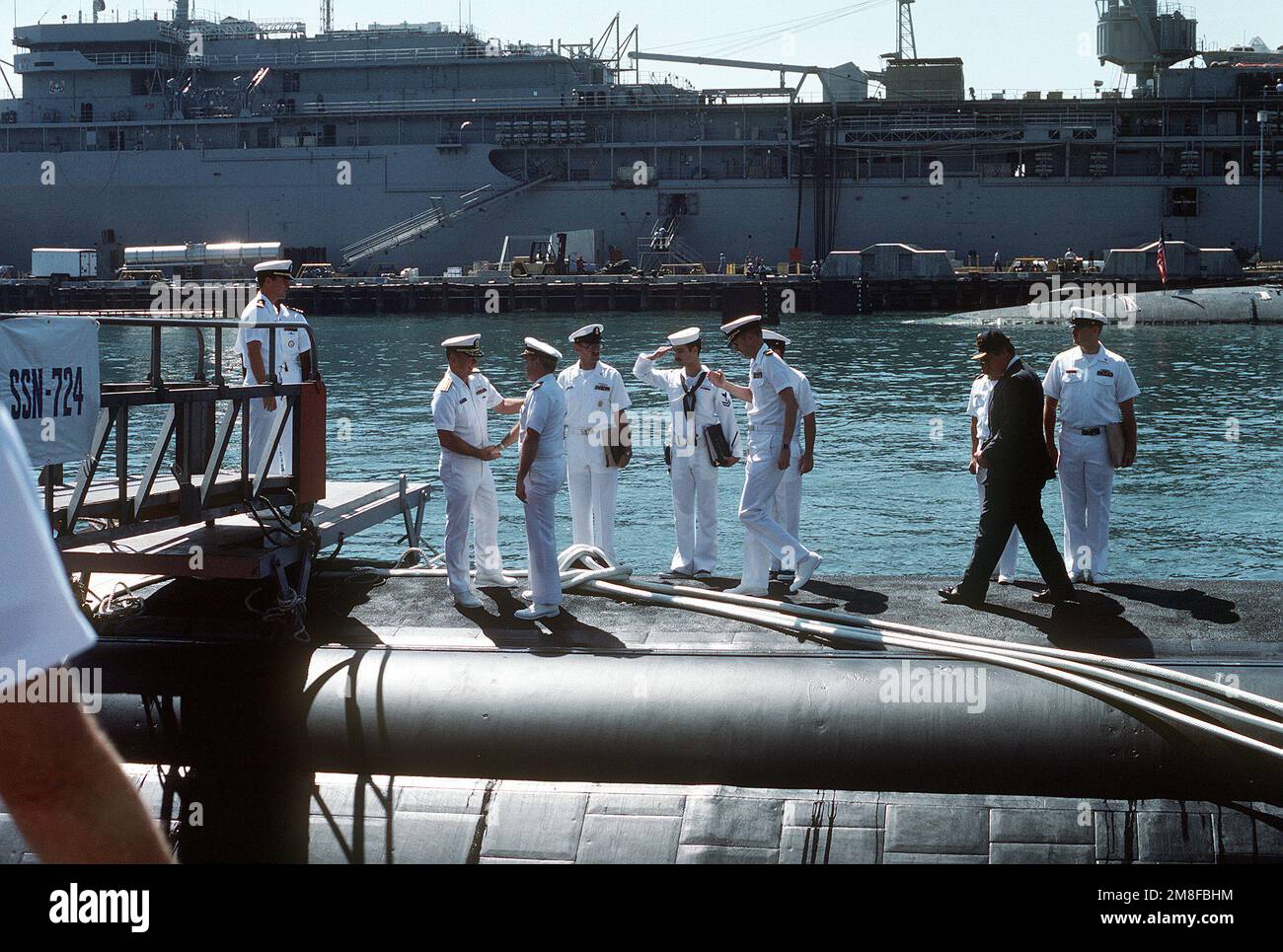 Crew members hold onto mooring lines on the deck of the nuclear-powered ...