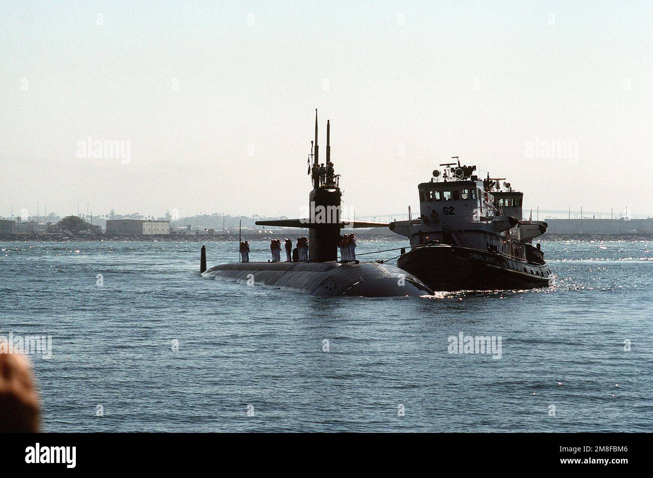 A commercial tug pushes the nuclear-powered attack submarine USS ...