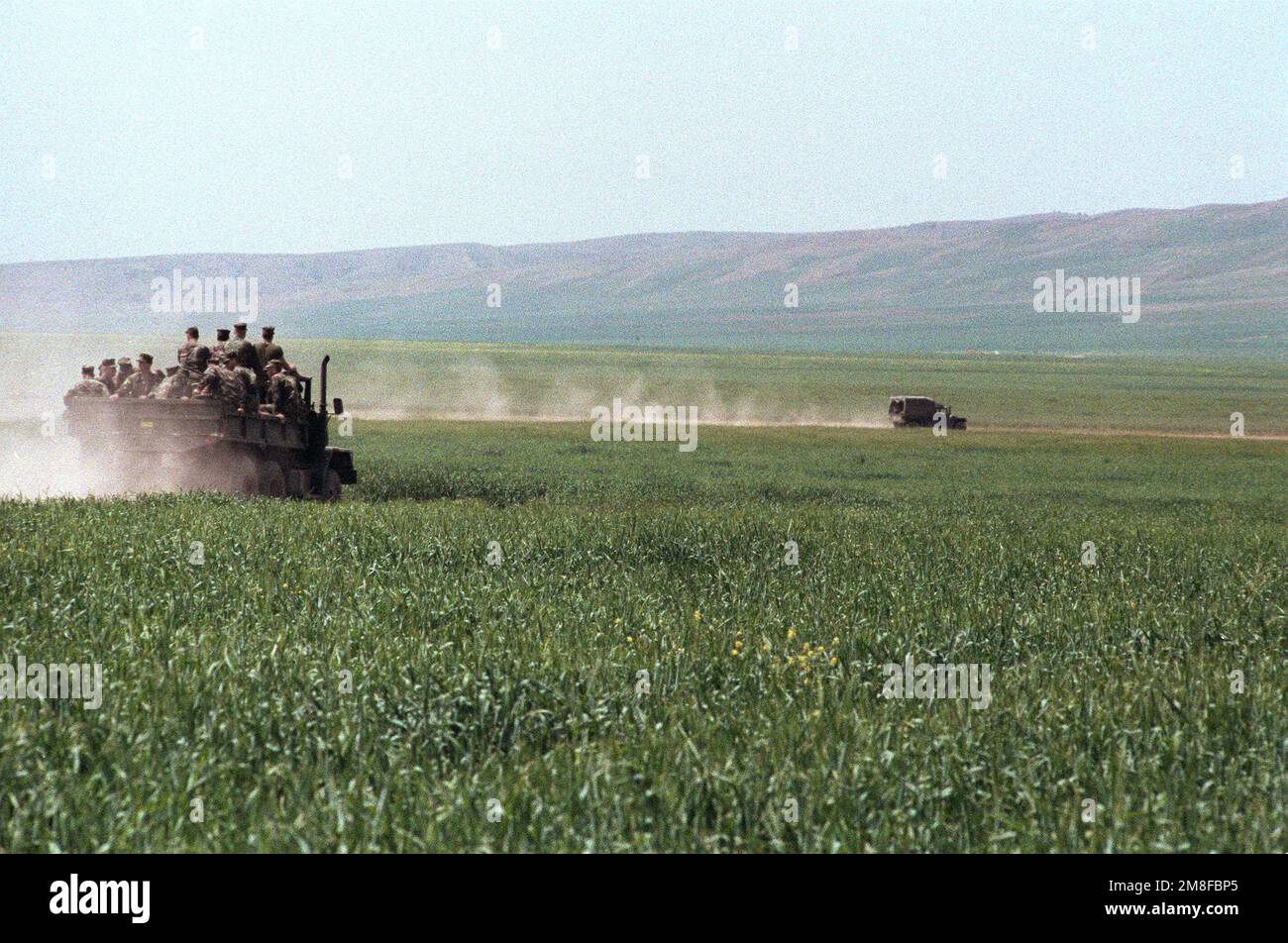 An M-939 5-ton cargo truck transports members of a U.S. Navy ...