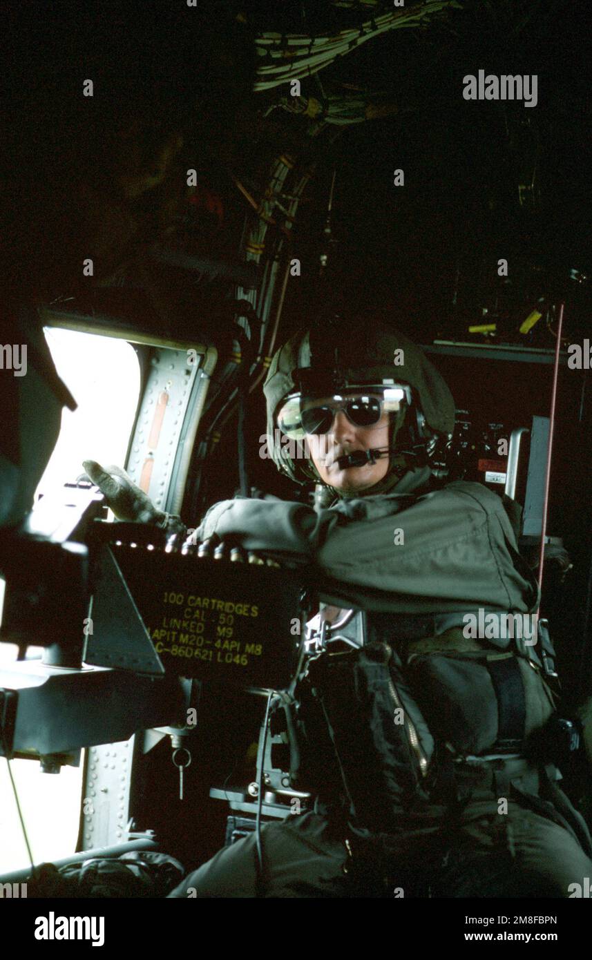 A gunner in a U.S. Army CH-47 Chinook helicopter mans a .50-caliber ...
