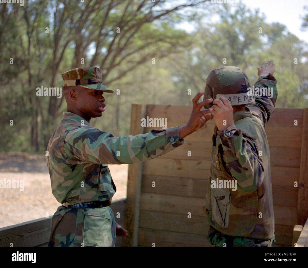 An instructor explains the proper method of throwing a practice grenade ...