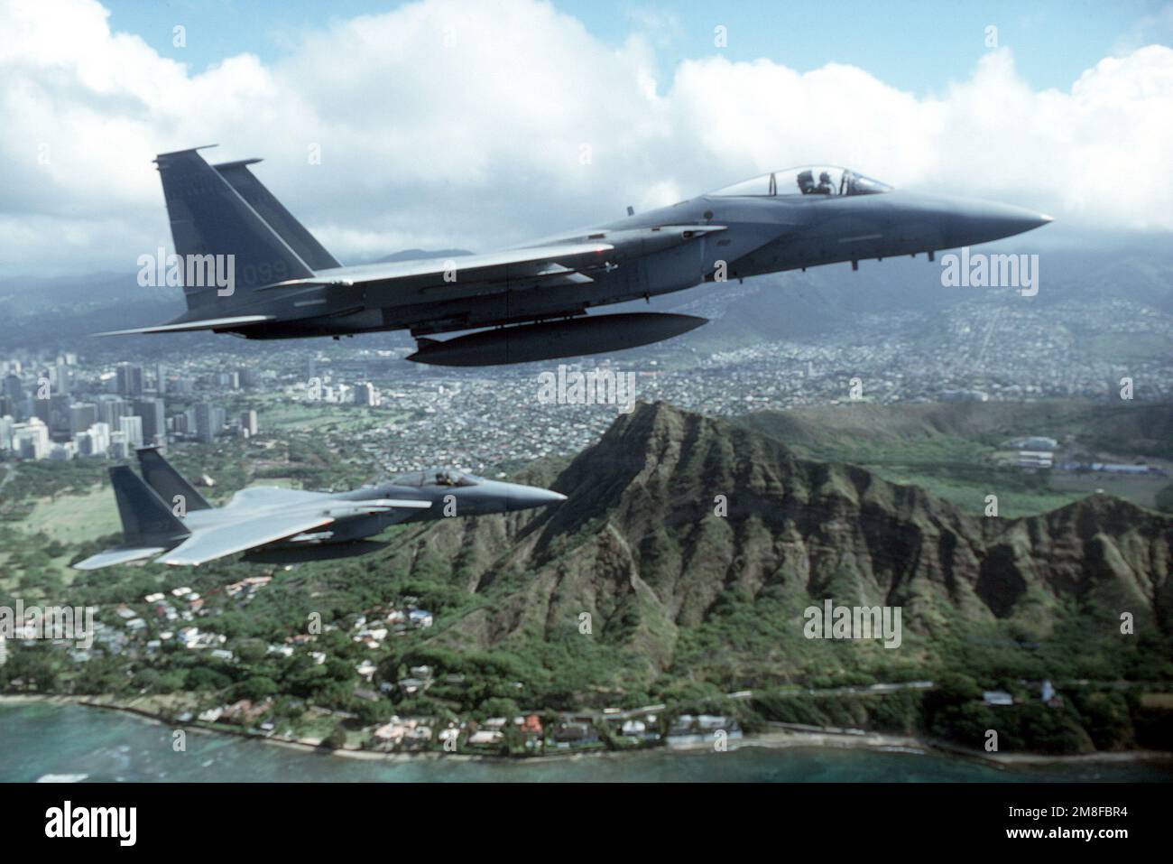 An air-to-air right side view of two F-15A Eagle aircraft from the ...