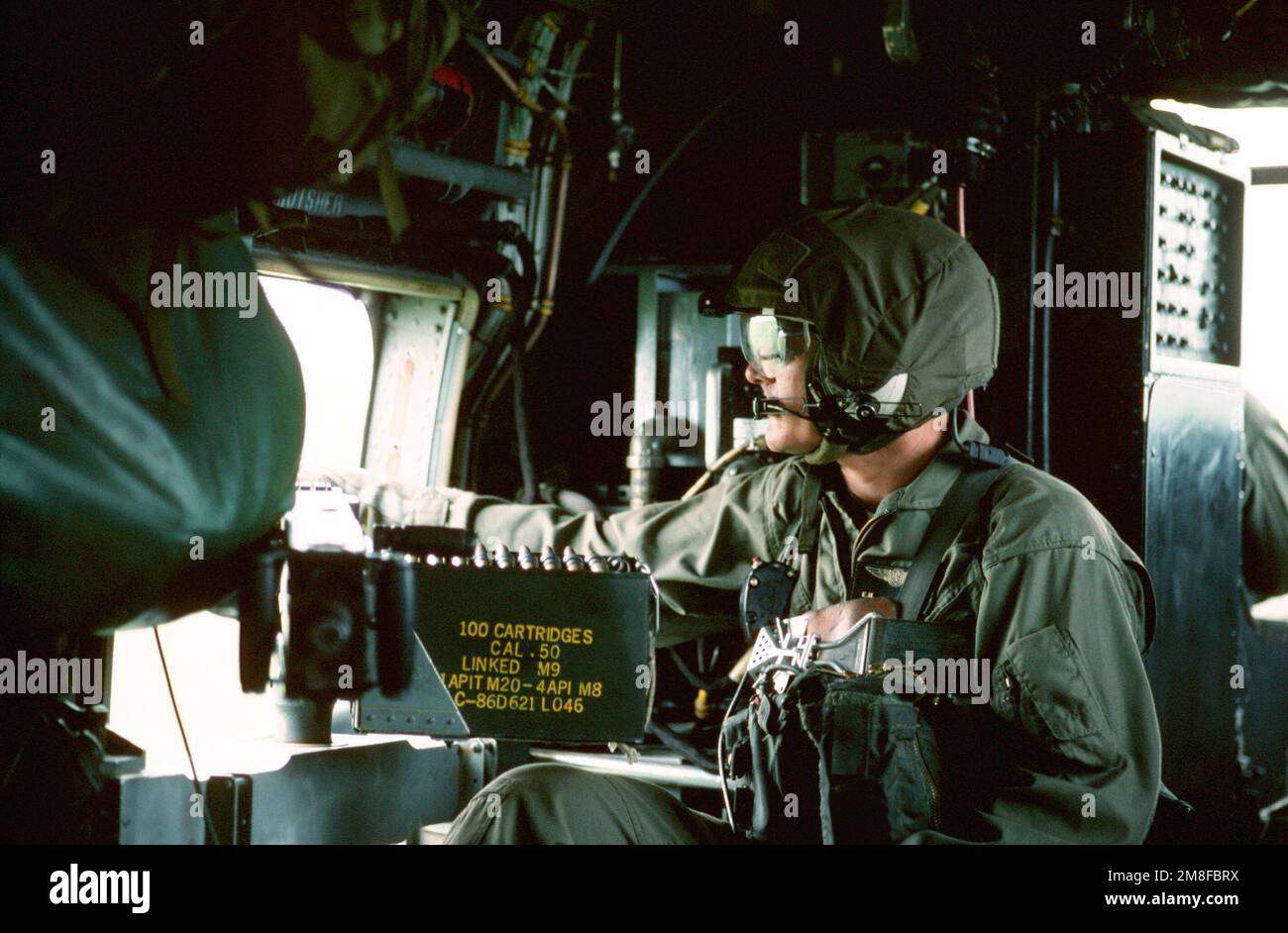 A gunner in a U.S. Army CH-47 Chinook helicopter mans a .50-caliber ...