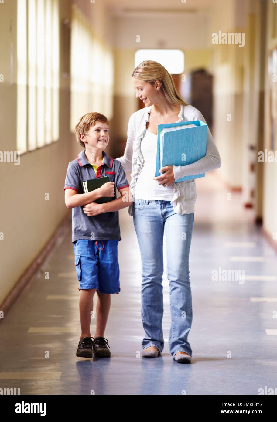 His favorite teacher. A teacher and young boy walking together down the ...