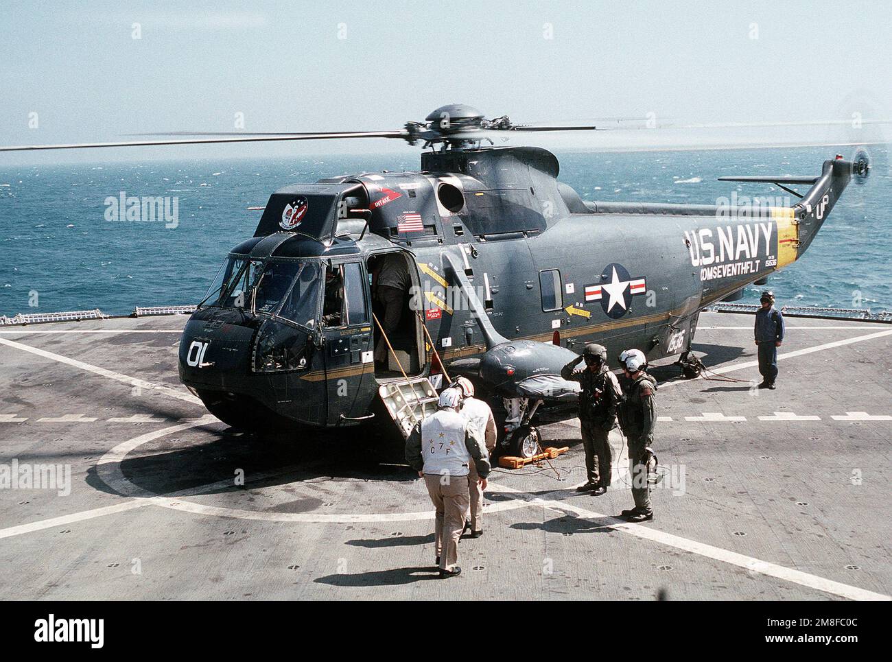 Helicopter crew members stand by as Vice Adm. Stanley R. Arthur ...