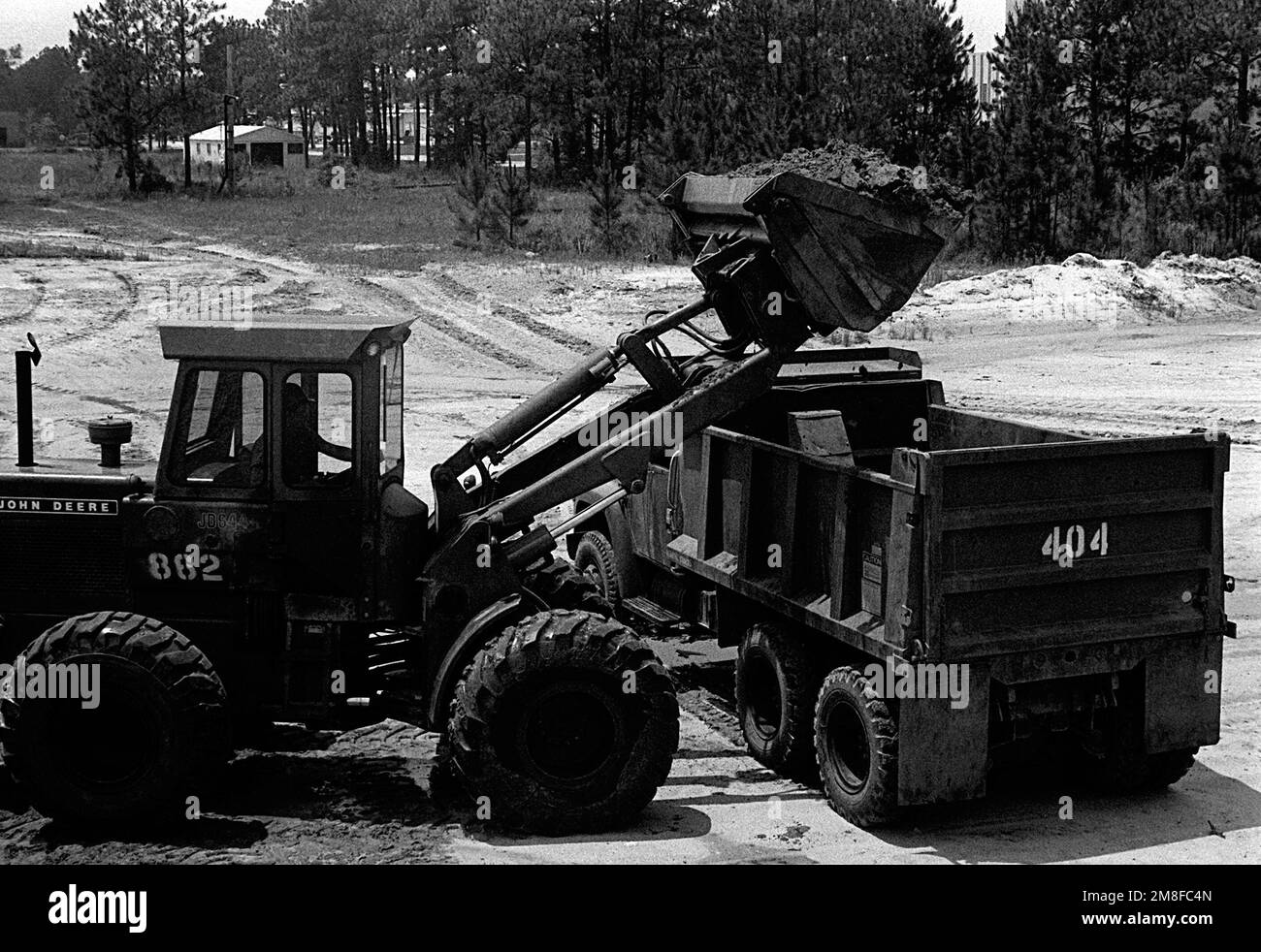 An equipment operator from a Navy Reserve Seabee unit positions the ...