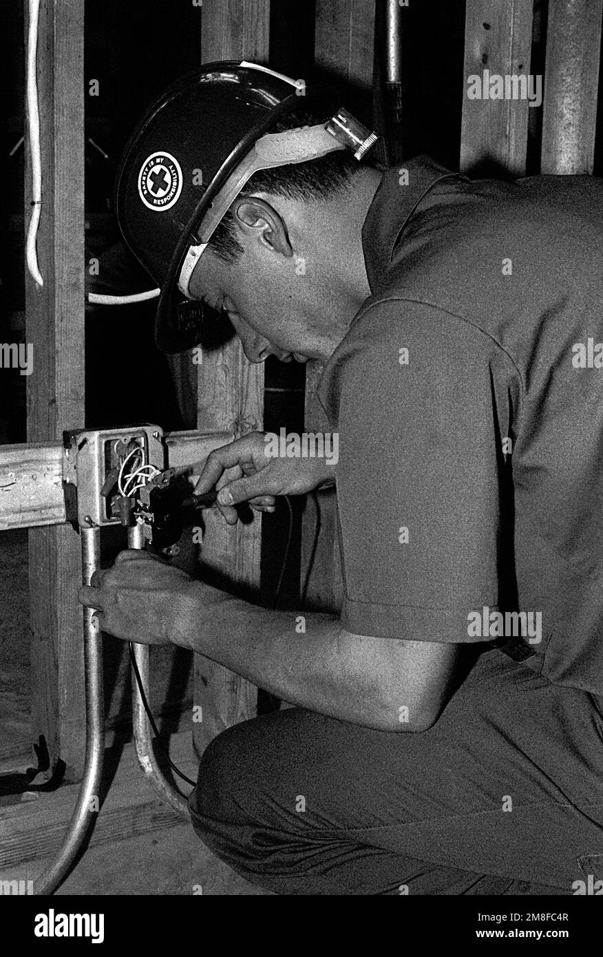 A construction electrician from a Navy Reserve Seabee unit checks the ...